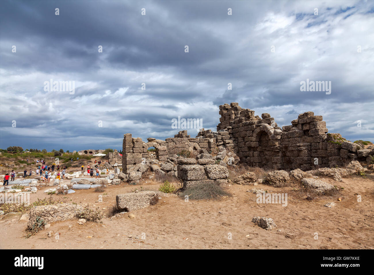 Tourists visiting the ancient ruins in of the state agora. Side, Turkey ...
