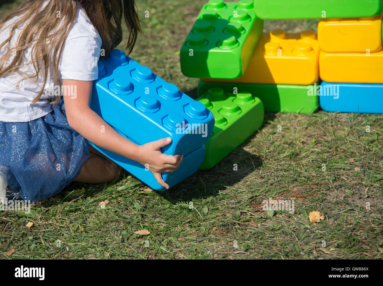 young girl play with bricks in the garden Stock Photo - Alamy