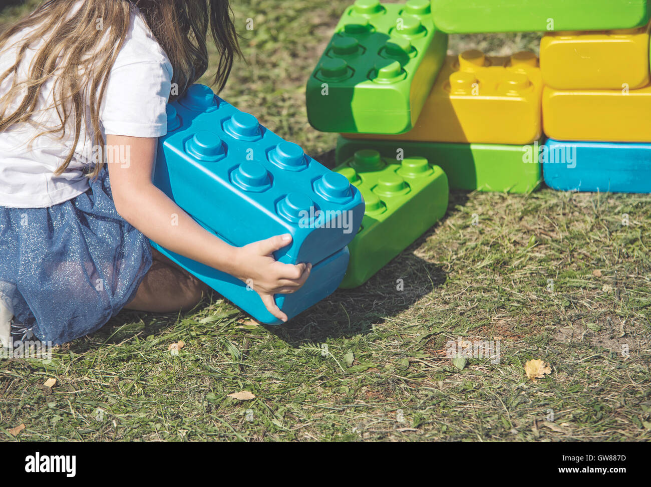 young girl play with bricks in the garden, hdr effect Stock Photo - Alamy
