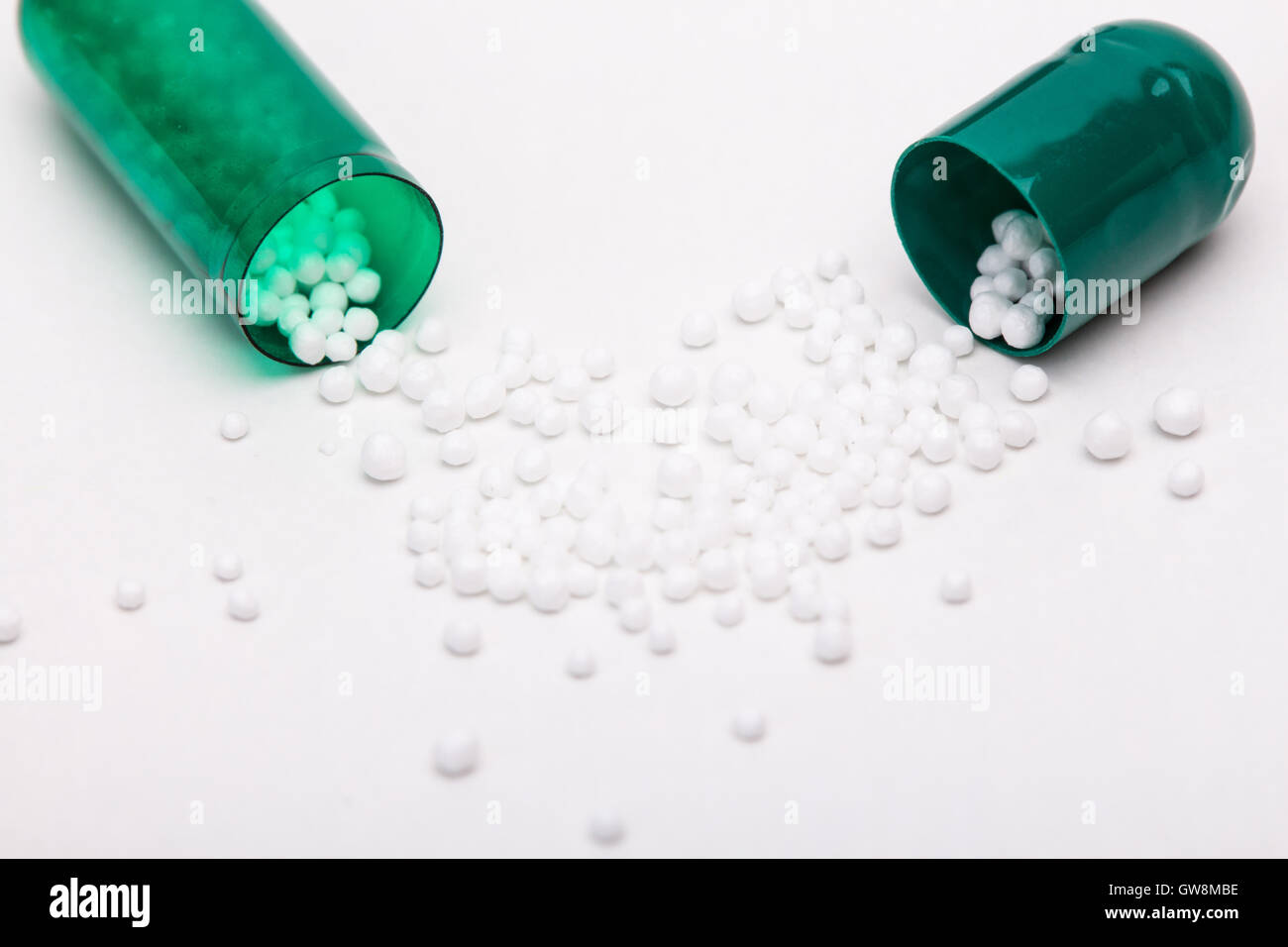 Green capsule opened with small balls inside Stock Photo - Alamy