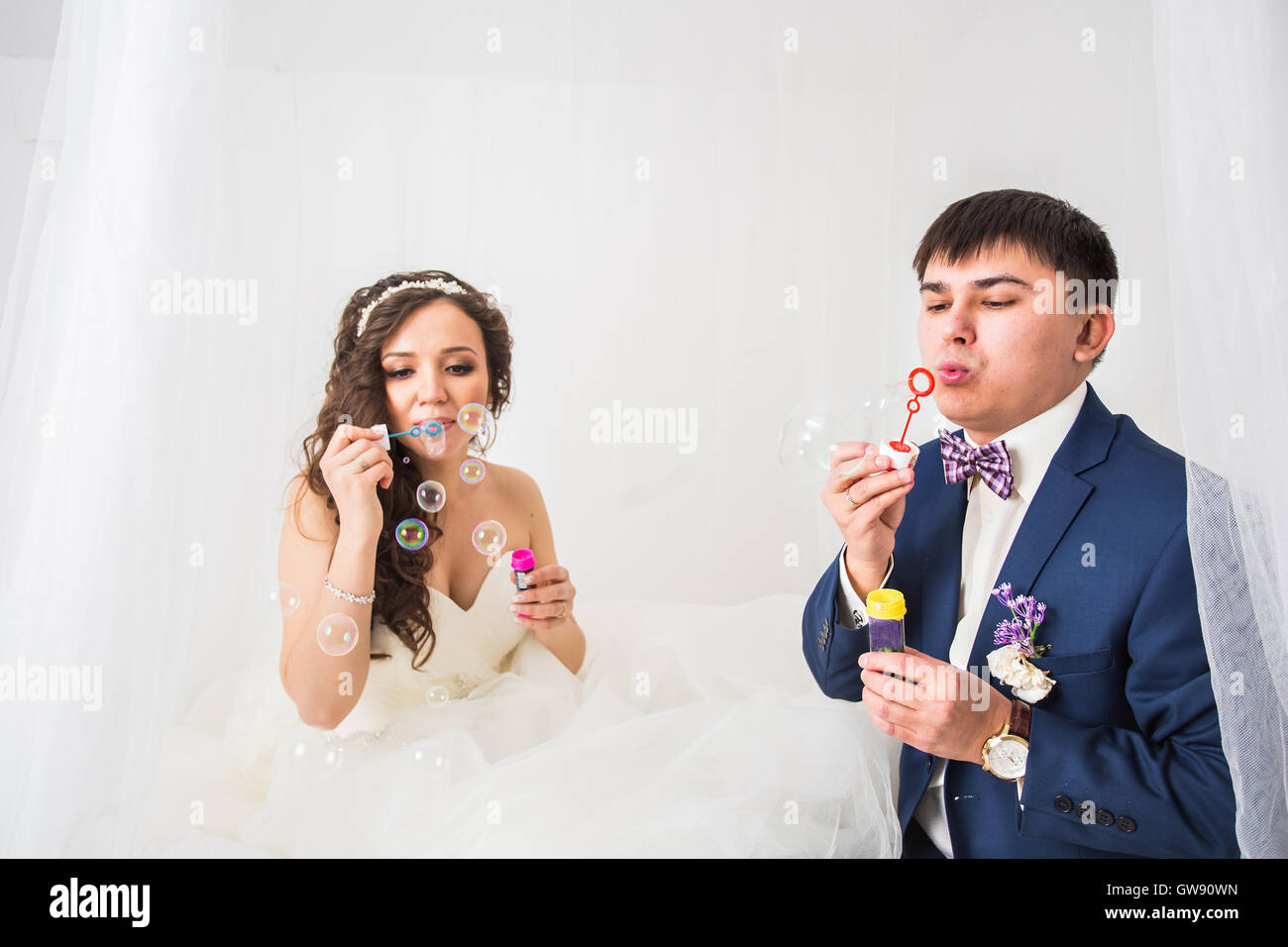 beautiful wedding couple blowing bubbles Stock Photo - Alamy