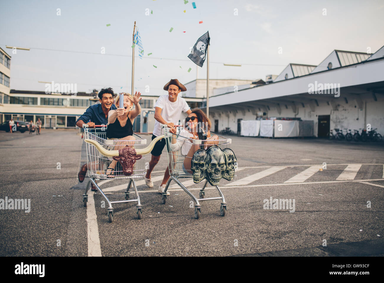 Multiracial group of friends racing with shopping cart. Young people ...