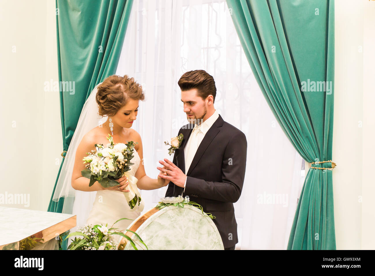 Bride putting on wedding ring Stock Photo - Alamy