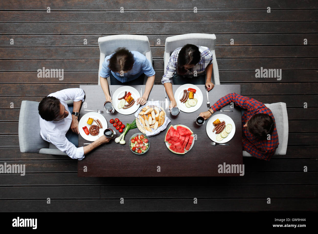 Four friends having dinner, top view Stock Photo - Alamy