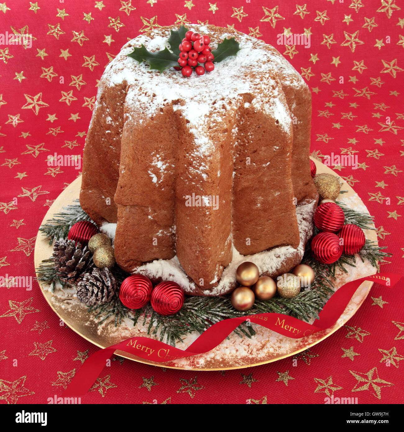 Pandoro christmas cake with holly, icing sugar dusting, bauble ...