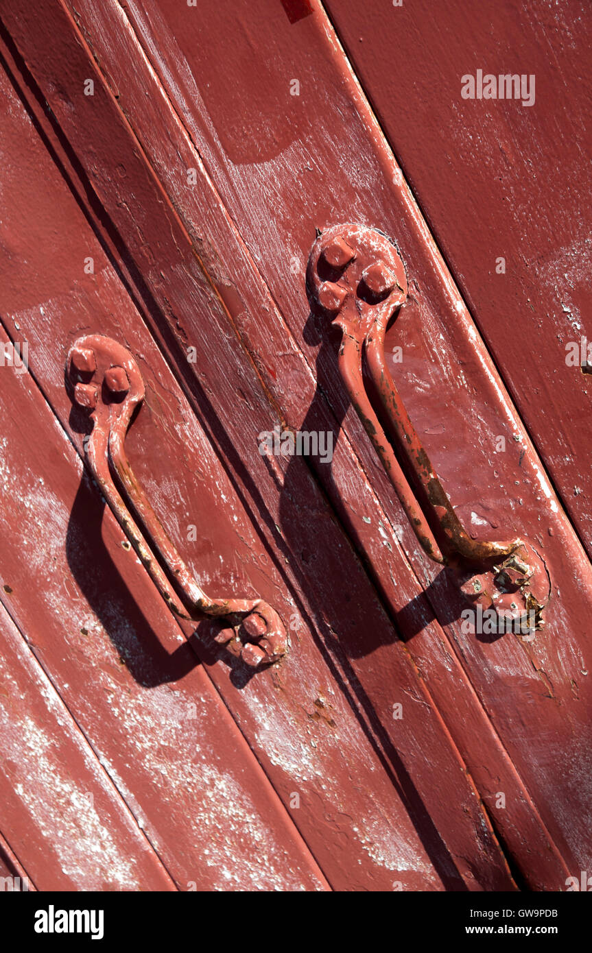 Painted handles on a red painted wooden barn door Stock Photo - Alamy