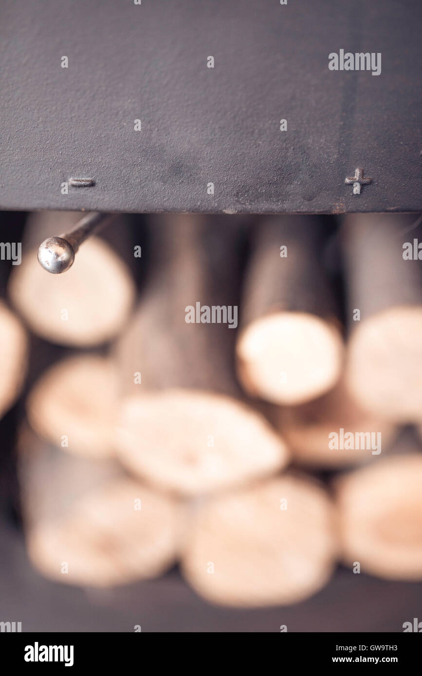 Prepared stack of firewood logs under cast iron metal plate. blurred ...