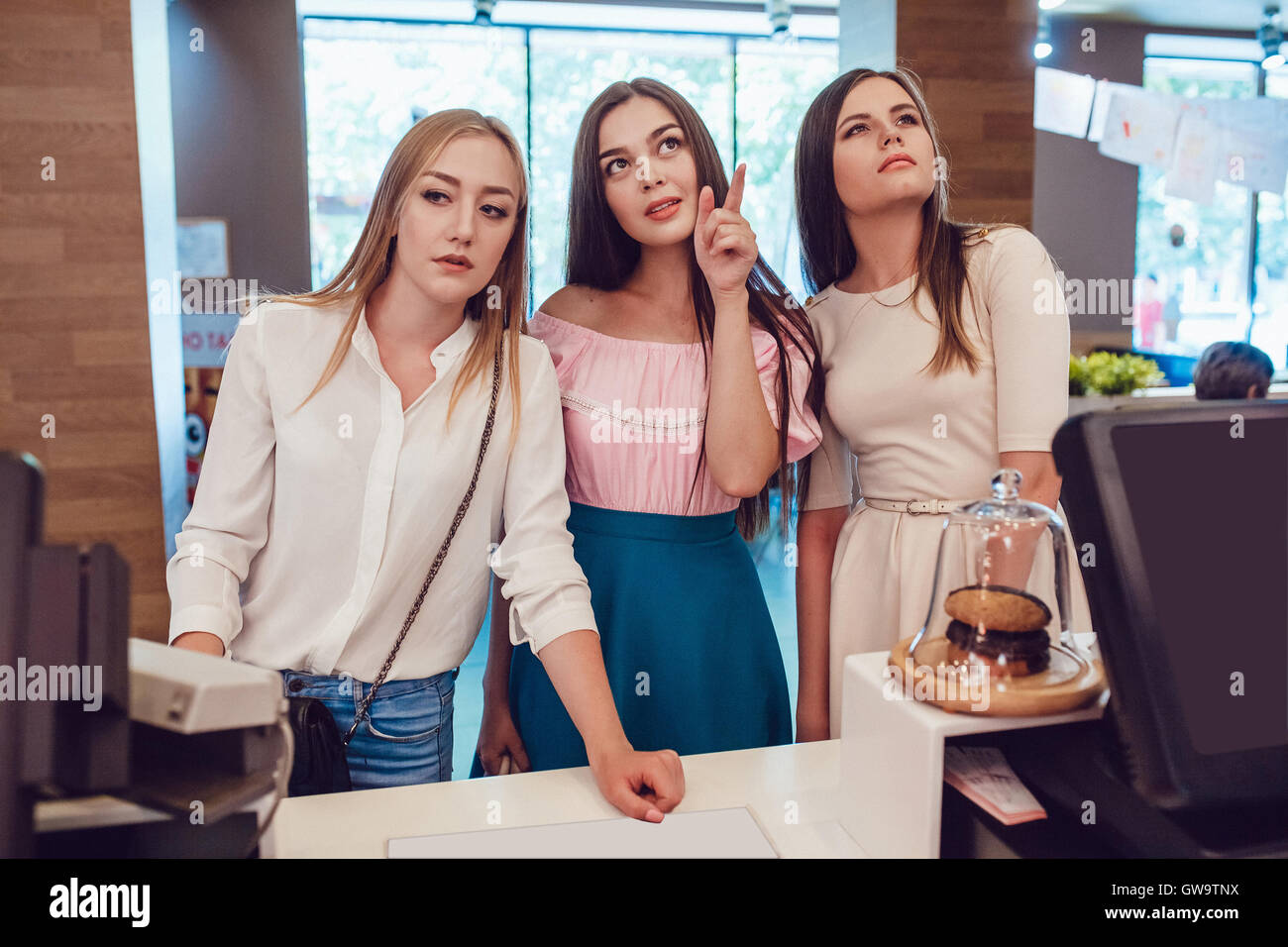 Three young girls make order in a fast food restaurant Stock Photo - Alamy