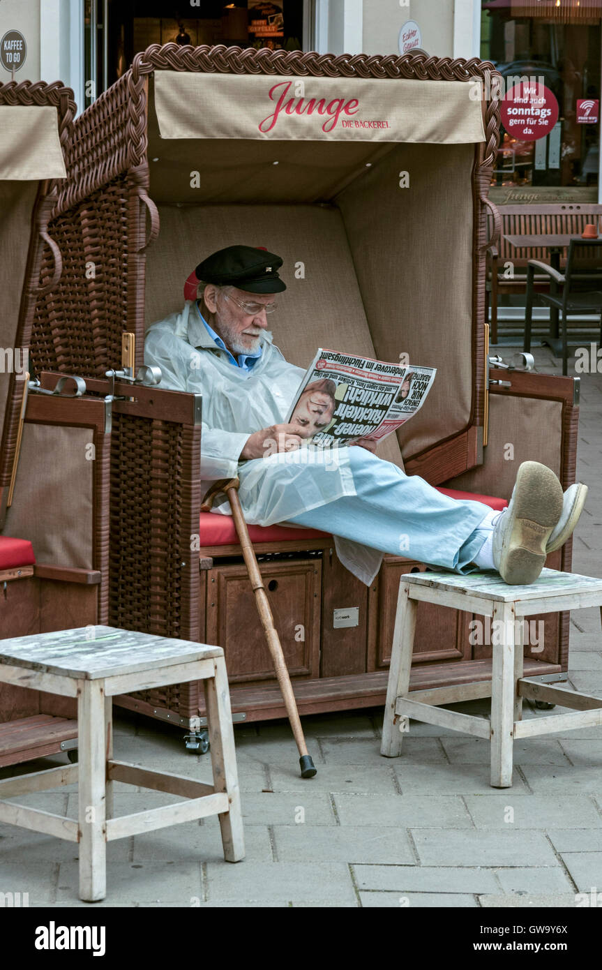 Man sitting on a chair reading a newspaper hi-res stock photography and ...