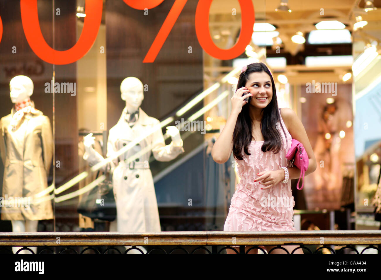 Young woman in shop calls by phone Stock Photo - Alamy
