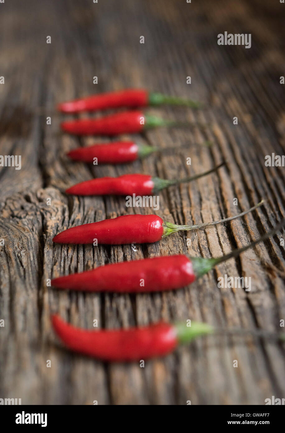 Red chili peppers on rustic background Stock Photo - Alamy