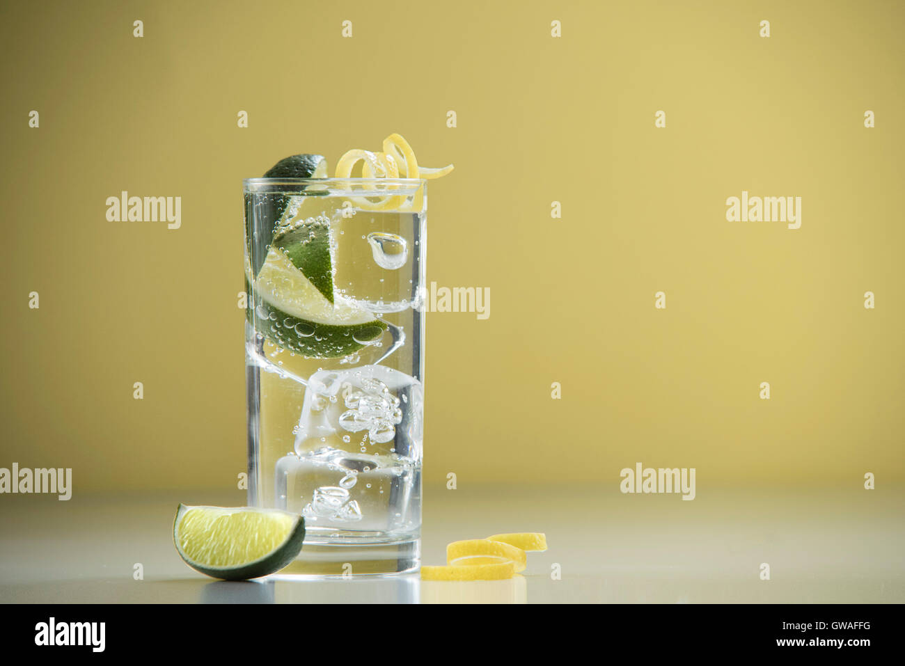 Glass of ice water with lemon and lime on yellow background Stock Photo ...