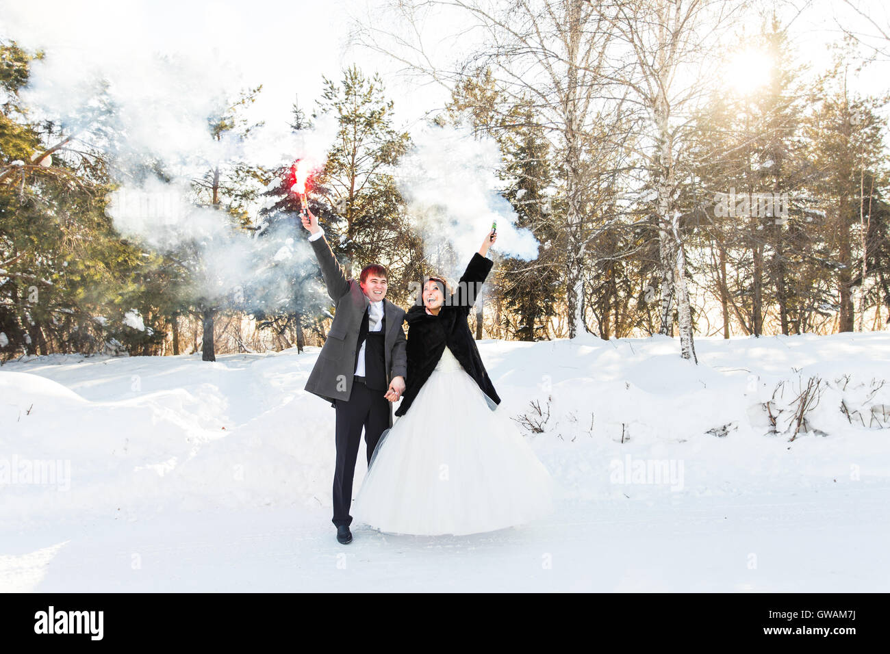 The bride and groom with smoke bombs in winter Stock Photo - Alamy