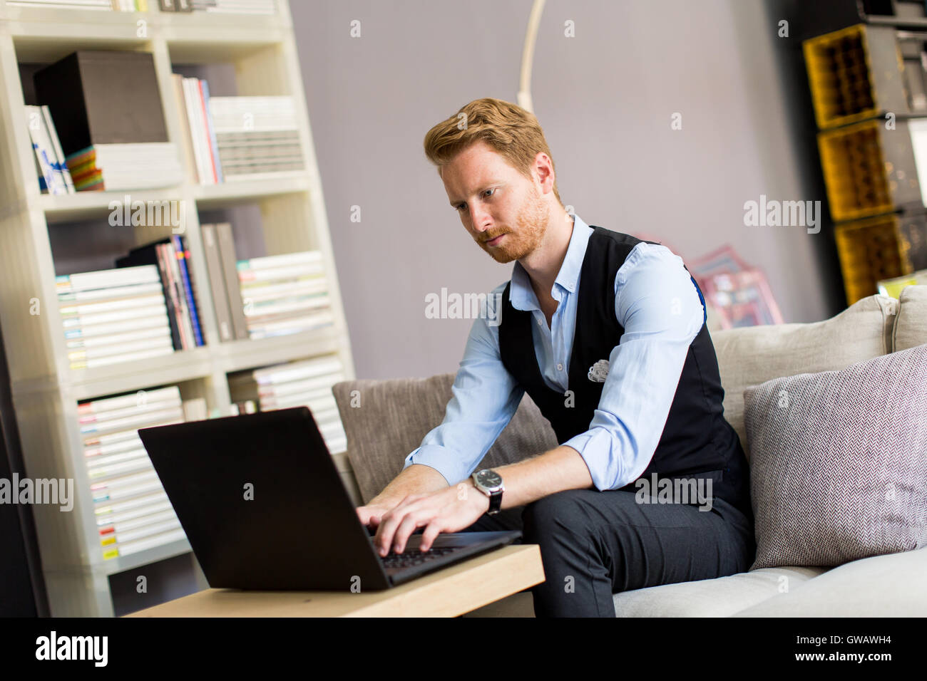 Young man working on laptop in he office Stock Photo - Alamy