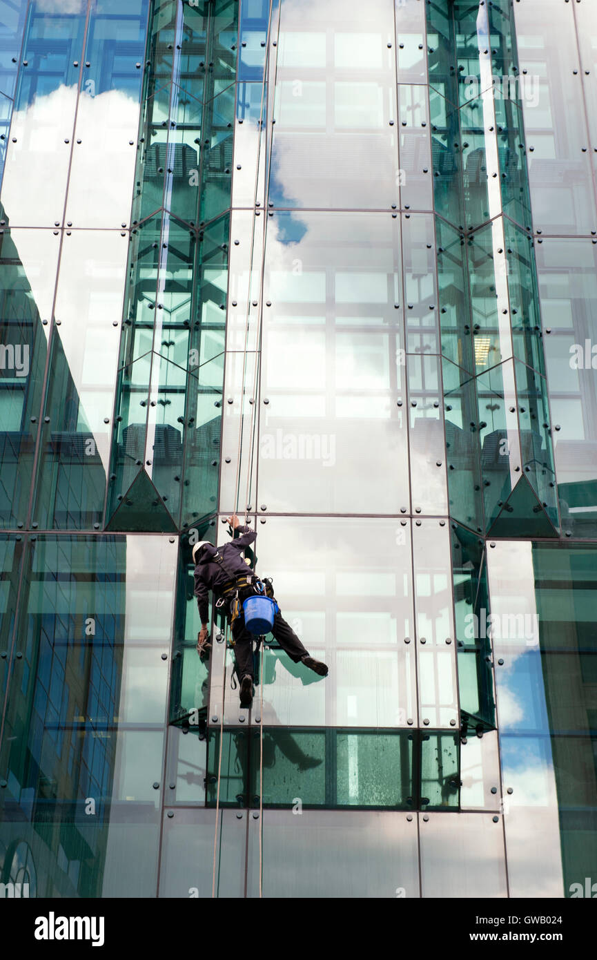 A window washer abseiling down the side of building, City of London, UK ...