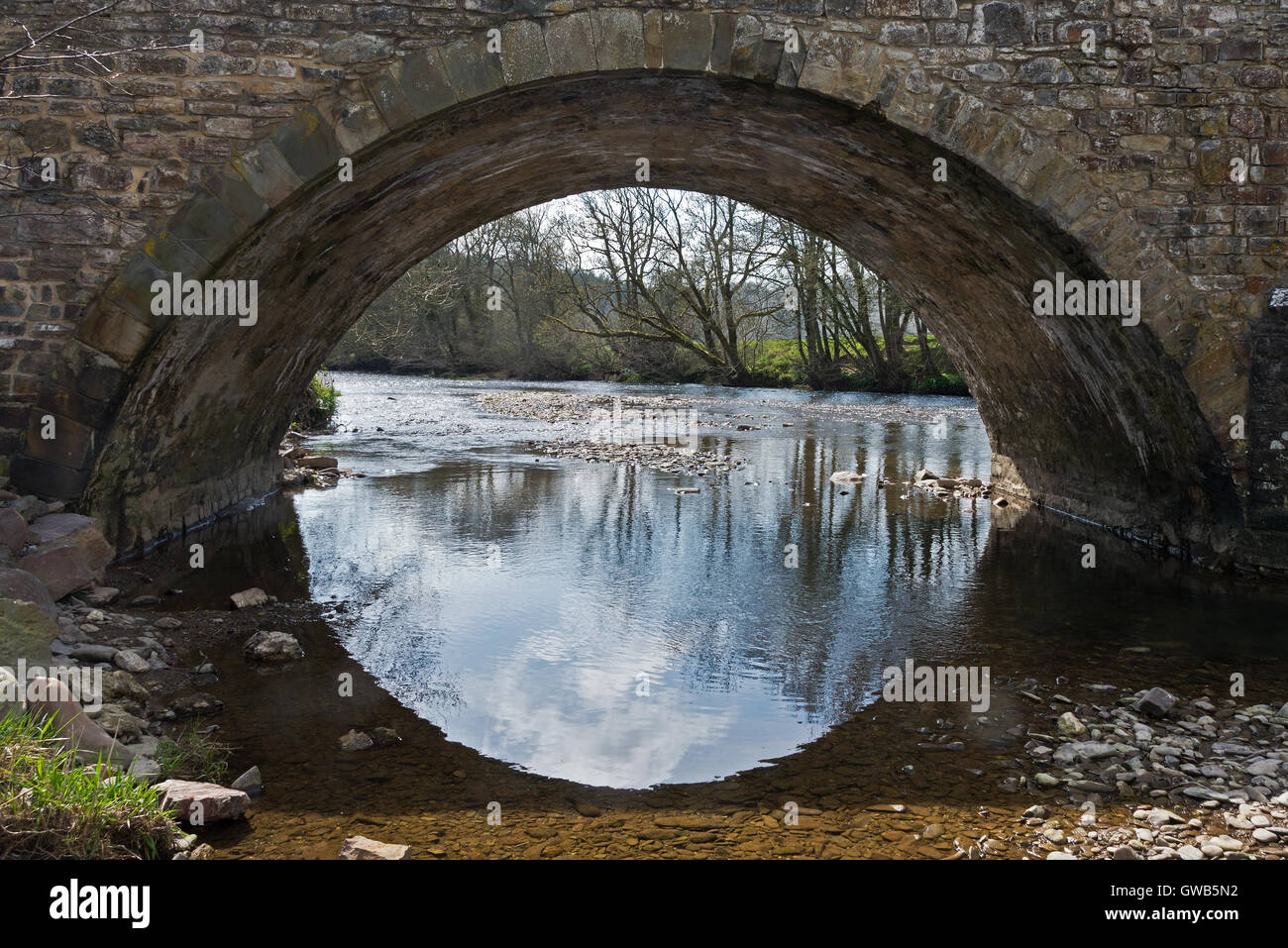A view through an arch of the bridge over the river Exe in the village ...