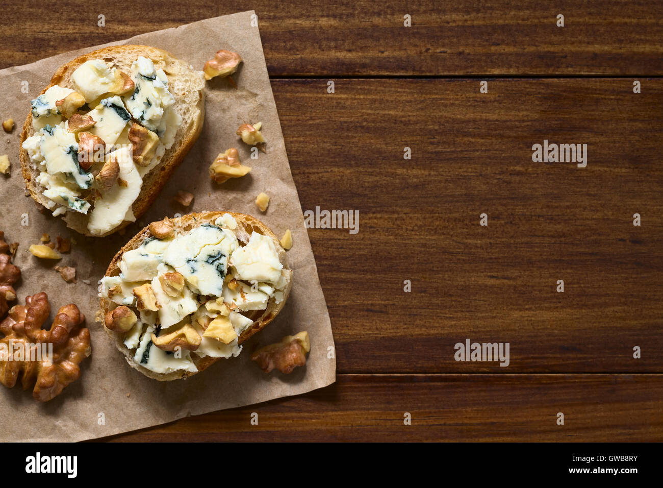 Blue cheese and walnut canapes, photographed overhead on dark wood with ...