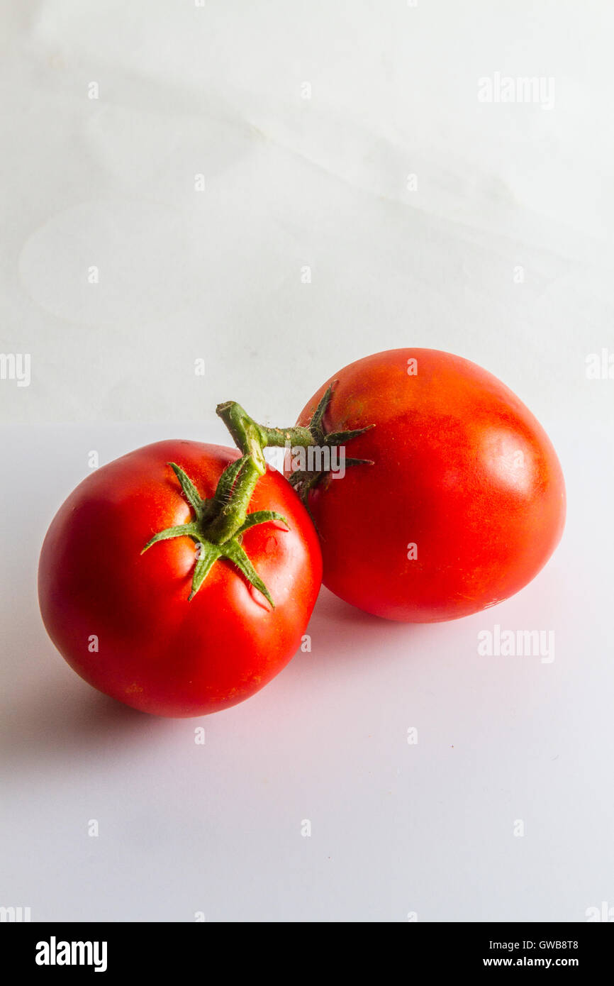 Two Tomatoes on the vine on a white background Stock Photo - Alamy