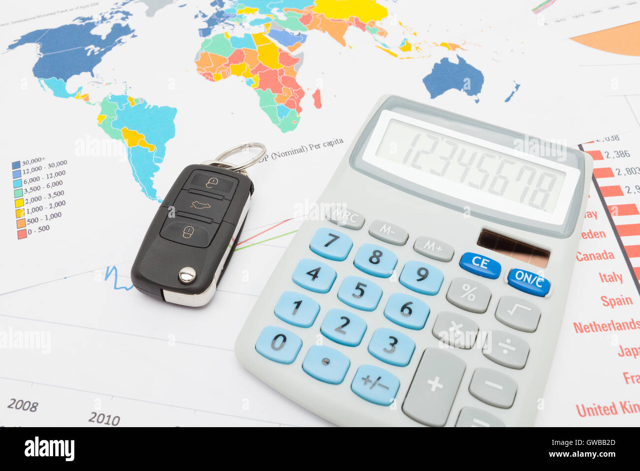 Car keys with calculator over world map Stock Photo - Alamy