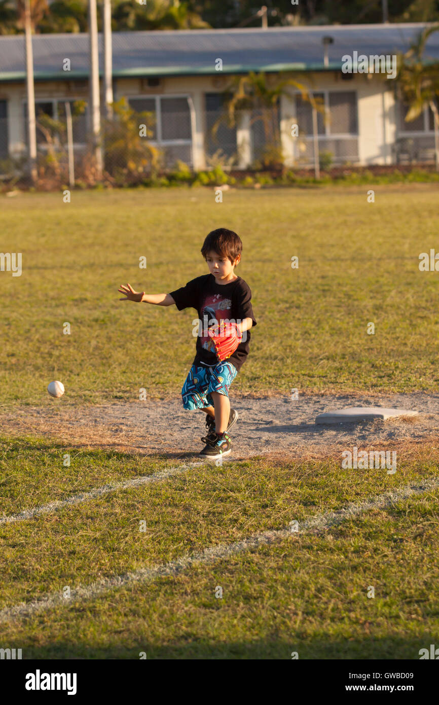 A young boy prepares to field the ball at first base during a game of ...