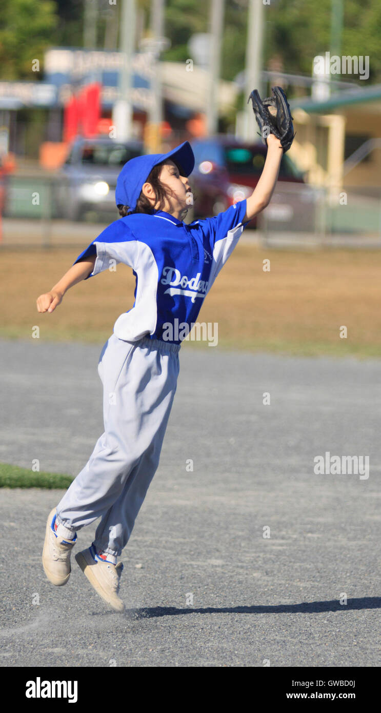 A young boy catches the ball during a baseball game in Cairns ...