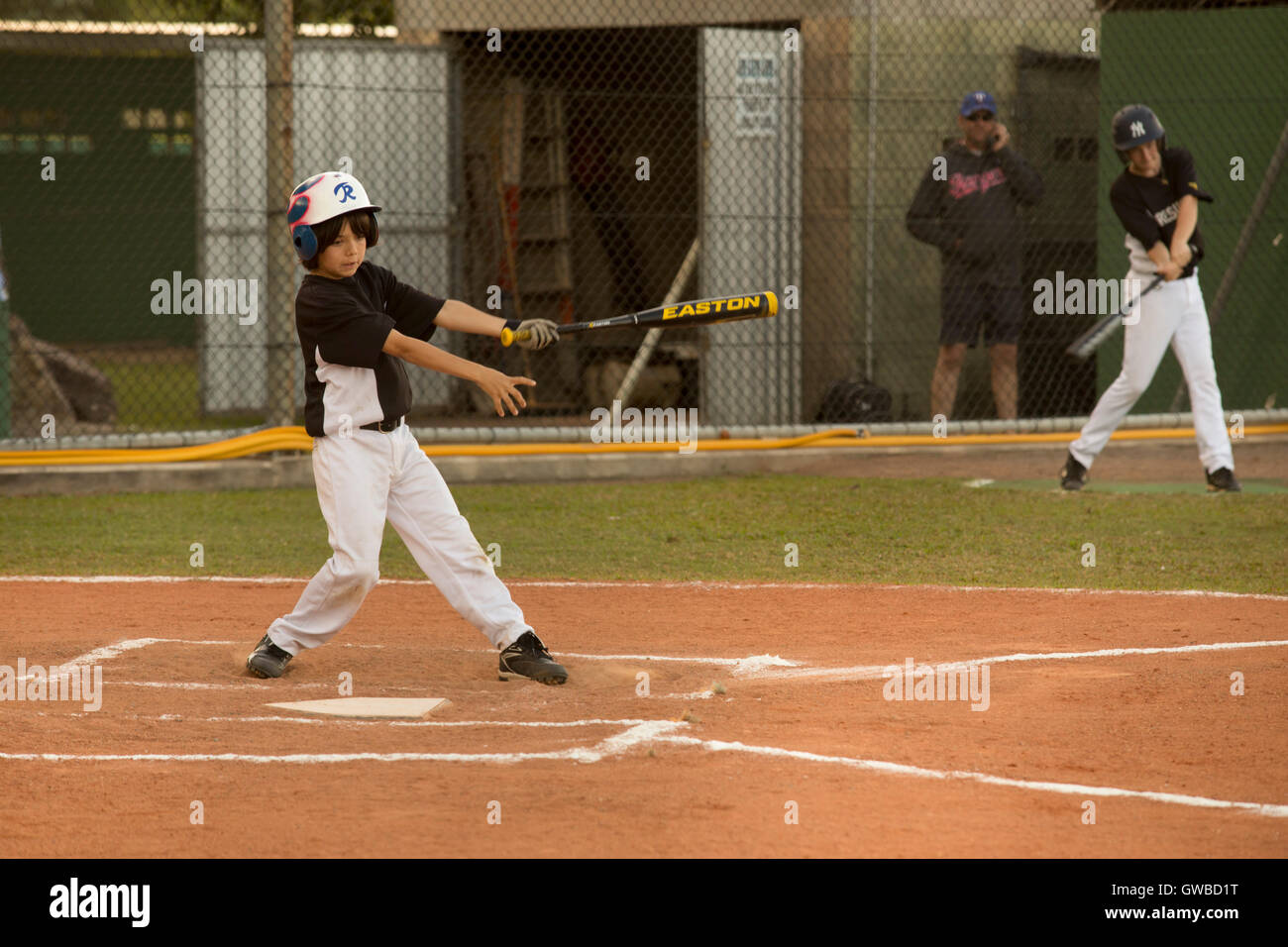 A young boy bats during a baseball game in Cairns, Australia Stock ...