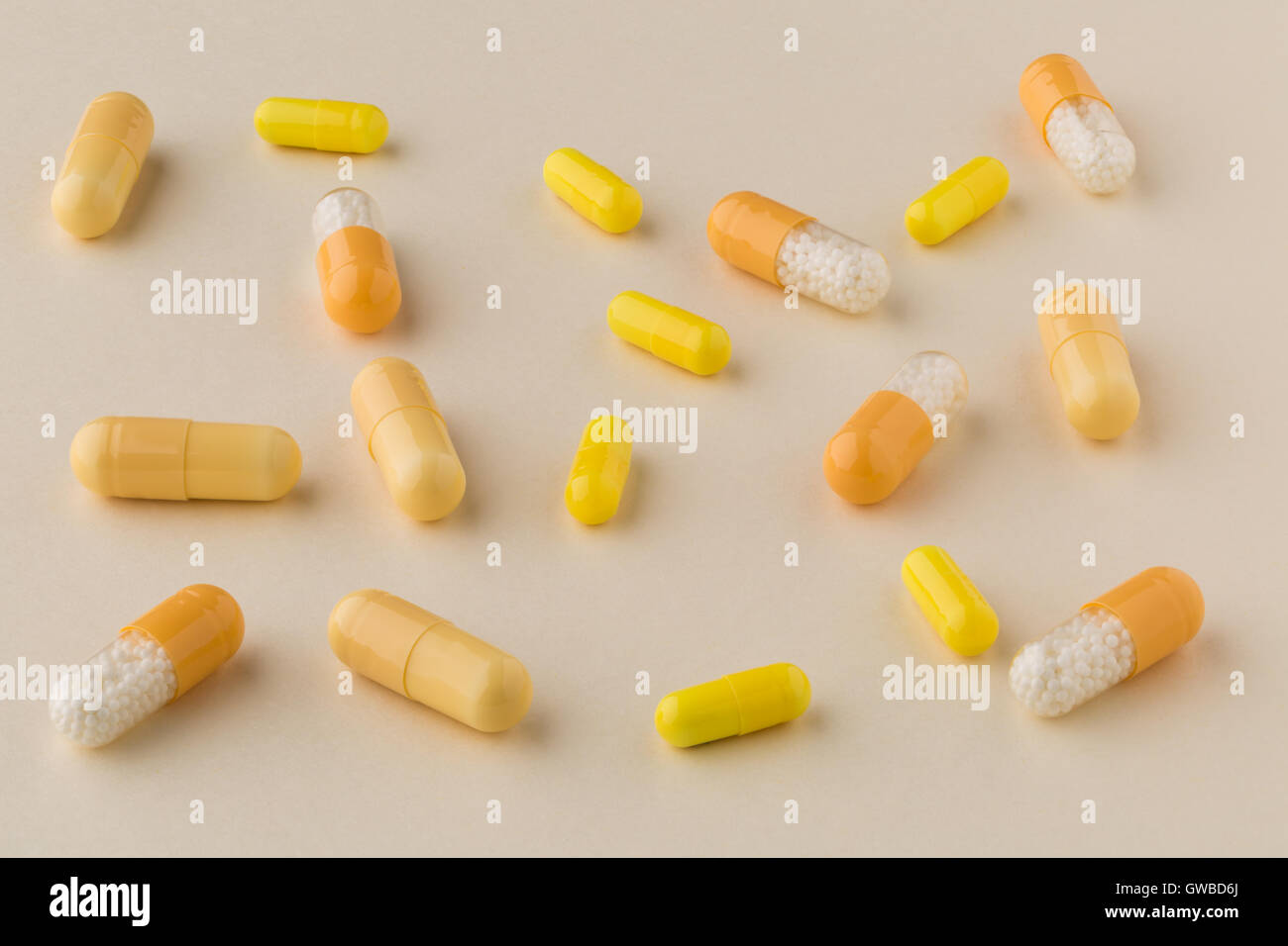 Various yellow medical capsules on light background Stock Photo - Alamy