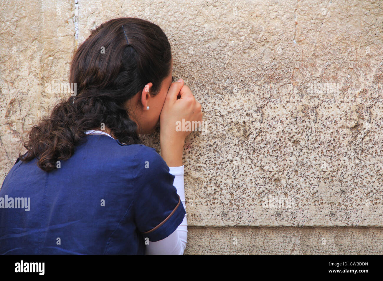 Woman passionately praying at the Western Wailing Wall also known as the Kotel in Jerusalem ...