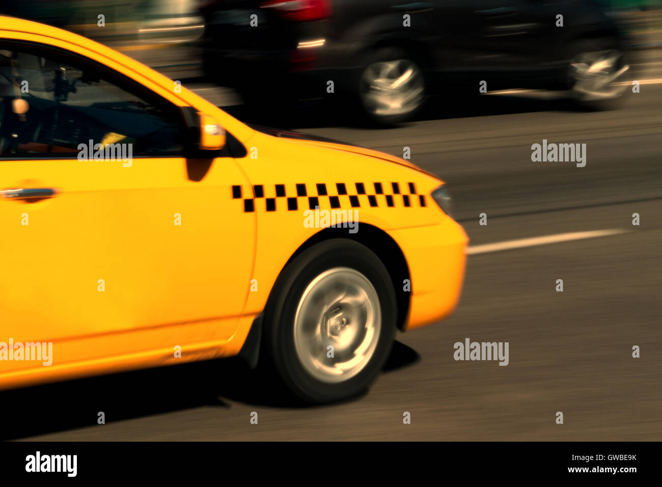 Urban scene: yellow taxi car going by a city street to its destination ...