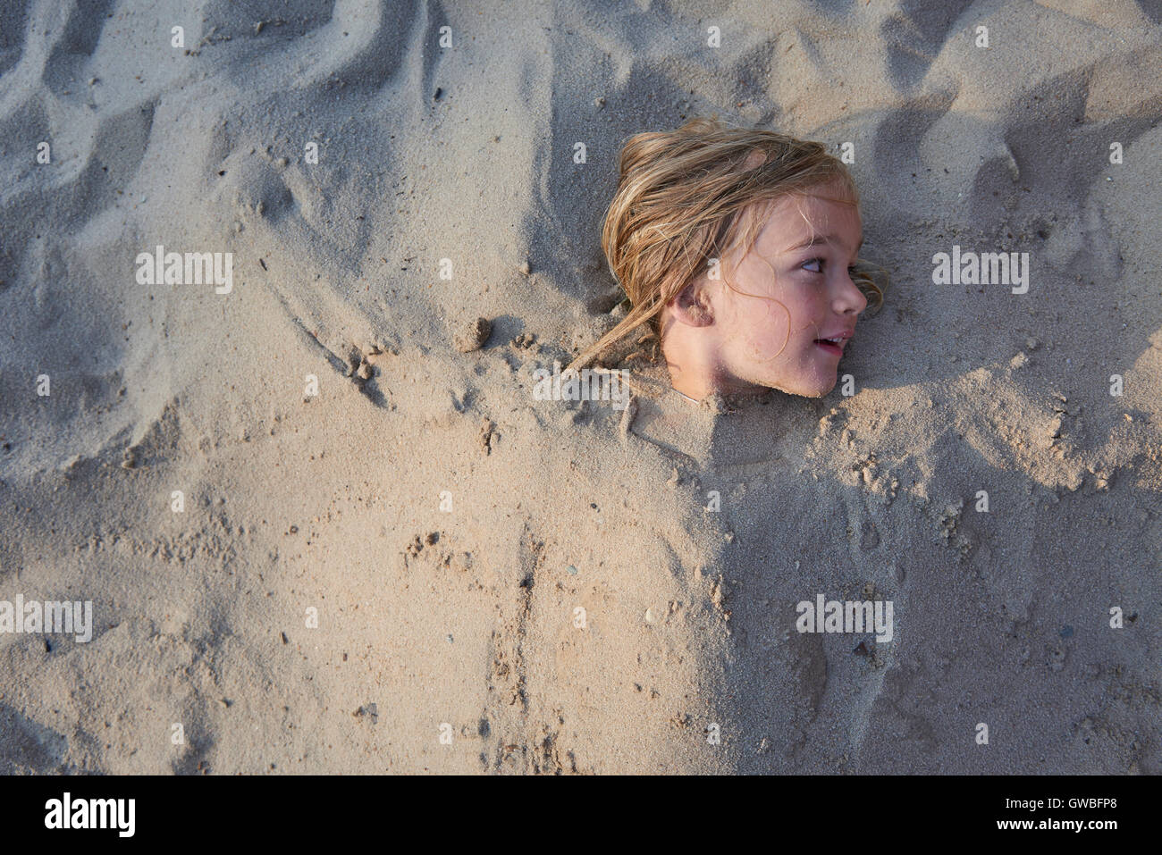 Girl Buried in the Sand at the Beach Stock Photo - Alamy