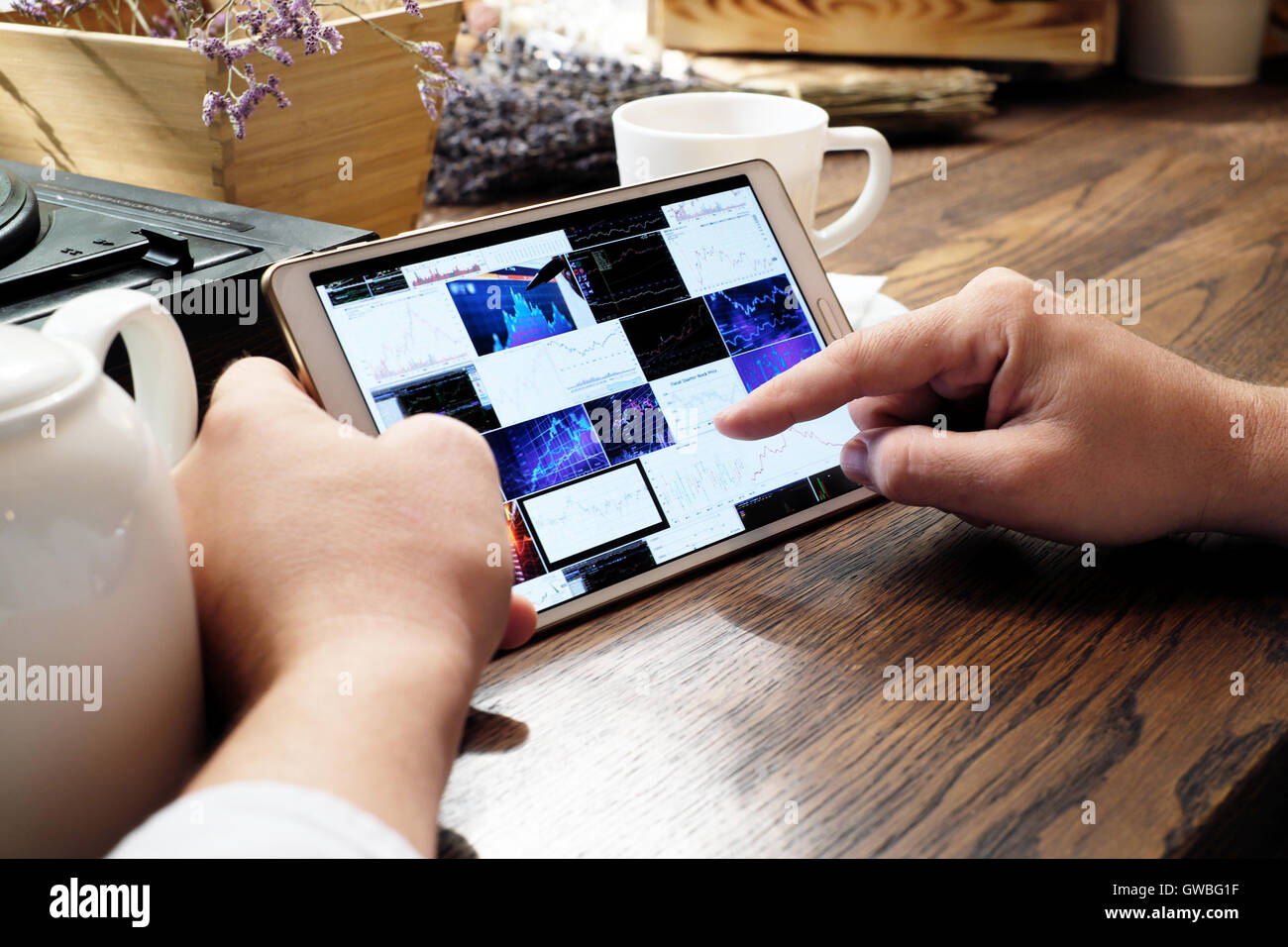 Tablet computer with stock analytics and abstract graphs in man hands ...