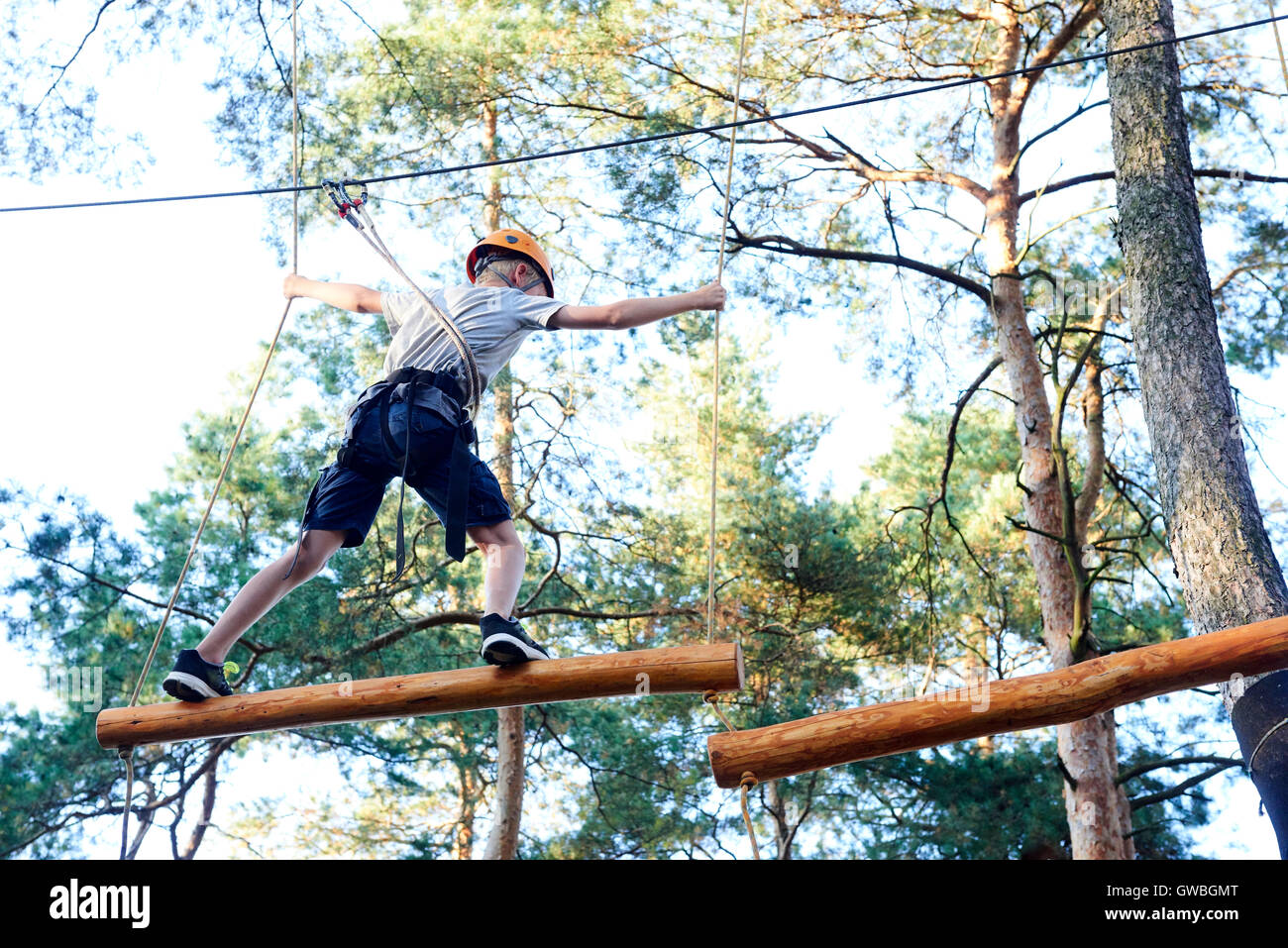 Portrait of active brave boy enjoying outbound climbing at adventure ...