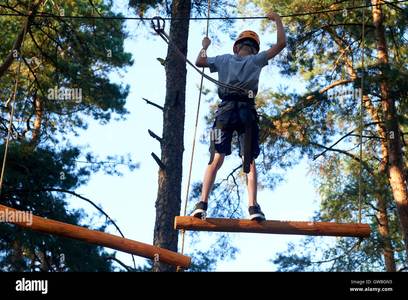 Portrait of active brave boy enjoying outbound climbing at adventure ...
