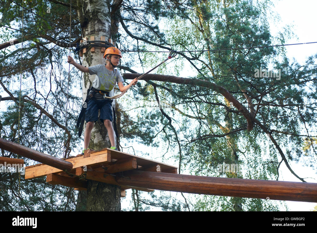 Portrait of active brave boy enjoying outbound climbing at adventure ...