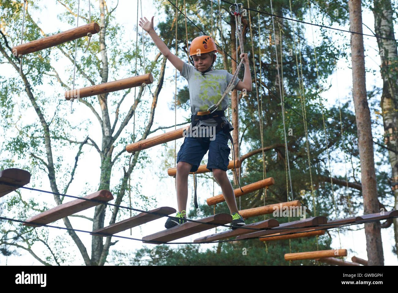 Portrait of active brave boy enjoying outbound climbing at adventure ...