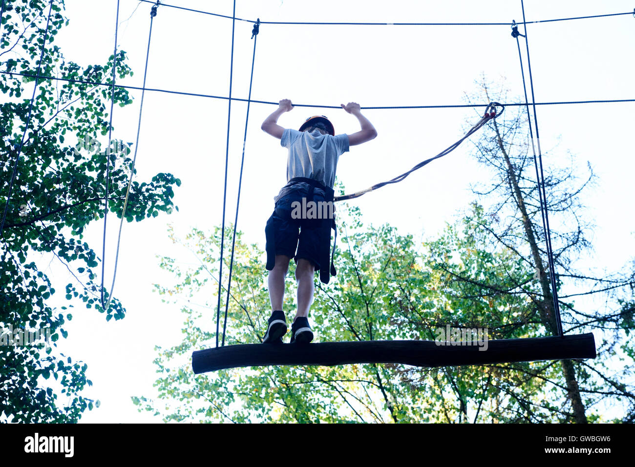 Portrait of active brave boy enjoying outbound climbing at adventure ...