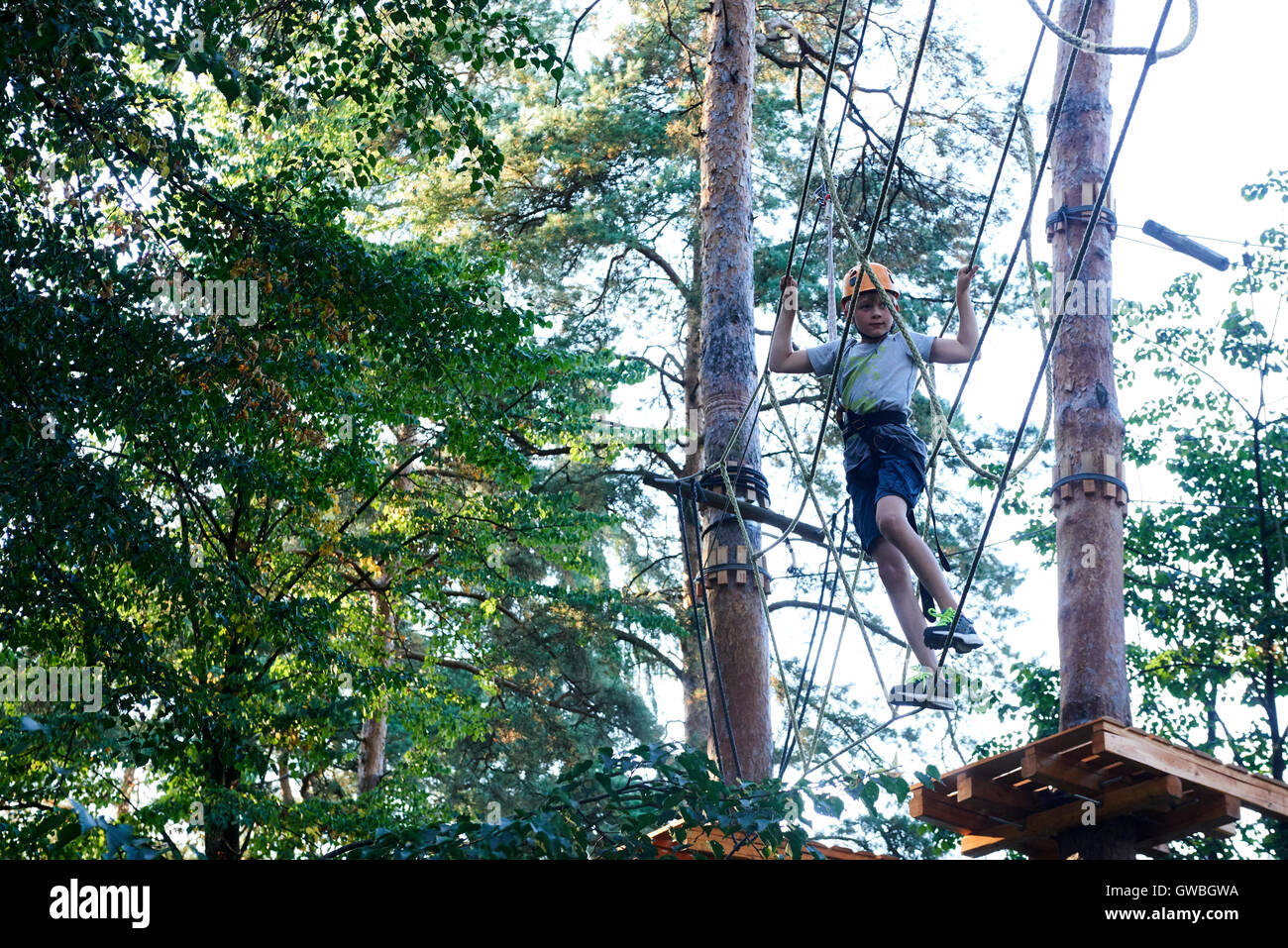 Portrait of active brave boy enjoying outbound climbing at adventure ...