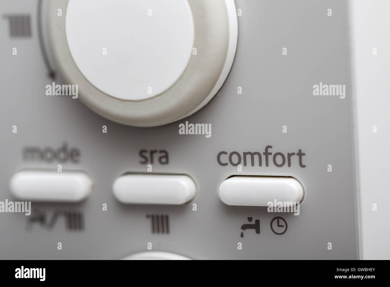 Close up on comfort button in control panel of central heating and DHW ...