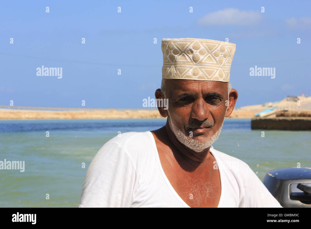 Sur, Oman, October 23, 2013: Omani fisherman at work. He is wearing the ...