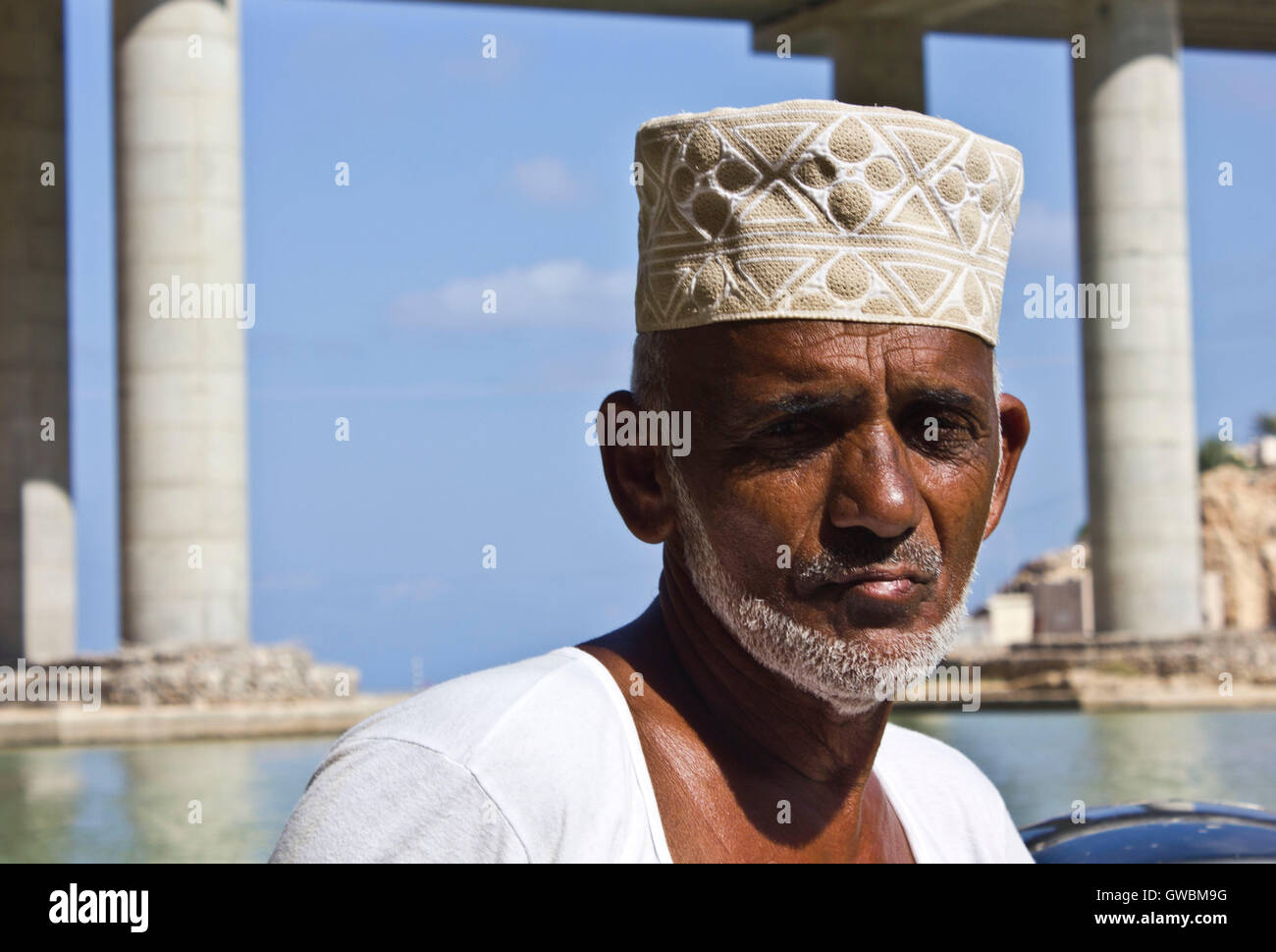Sur, Oman, October 23, 2013: Omani fisherman at work. He is wearing the ...