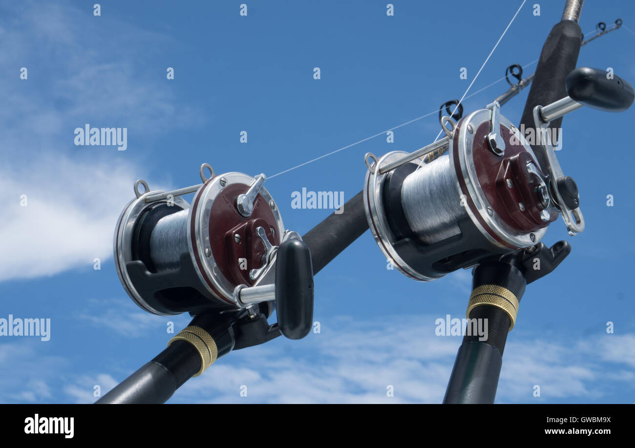 Fishing rods on a boat over blue sky. Picture of two fishing rods in ...