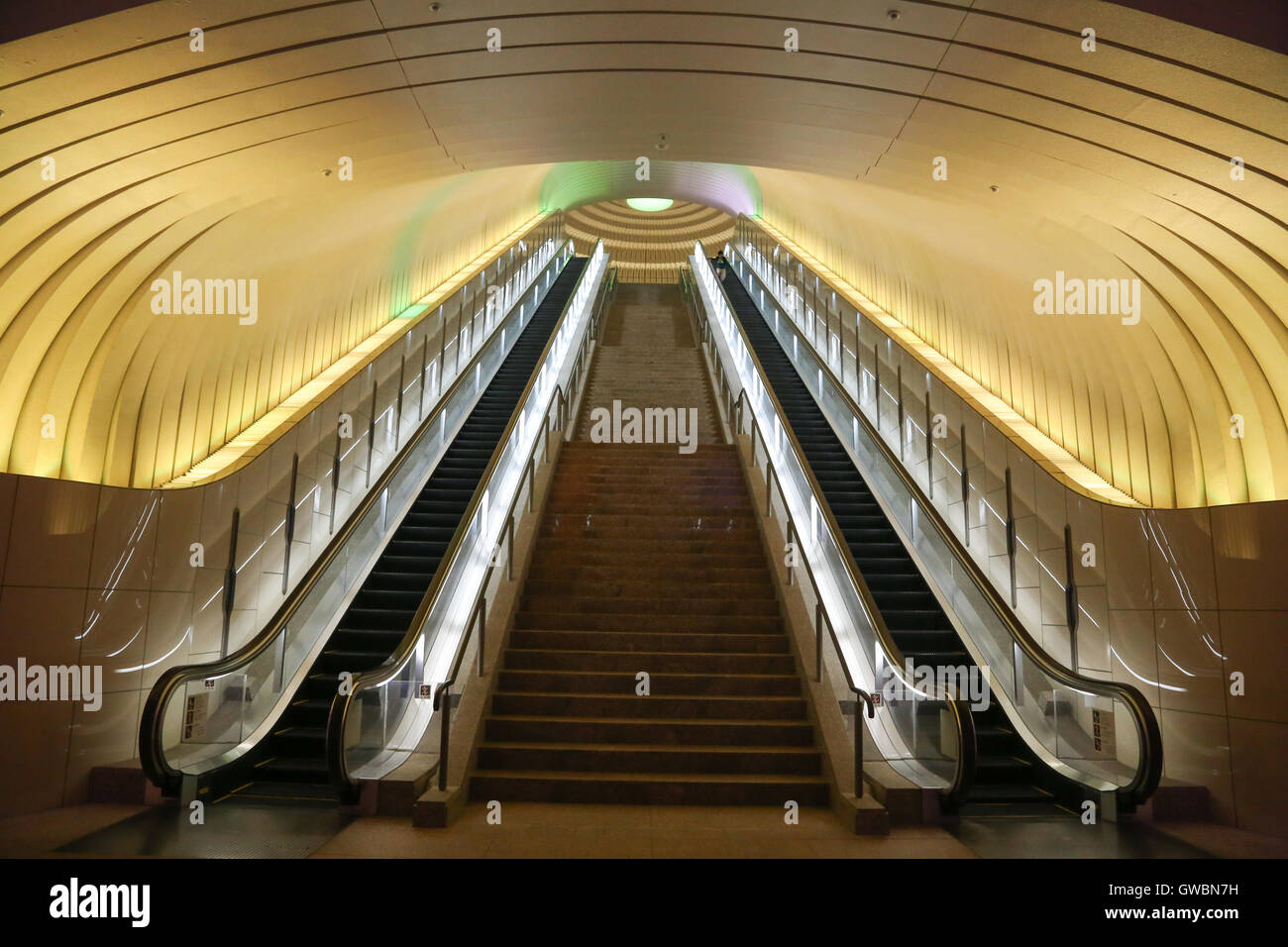 Two Escalators with Yellow Light overhead Stock Photo - Alamy