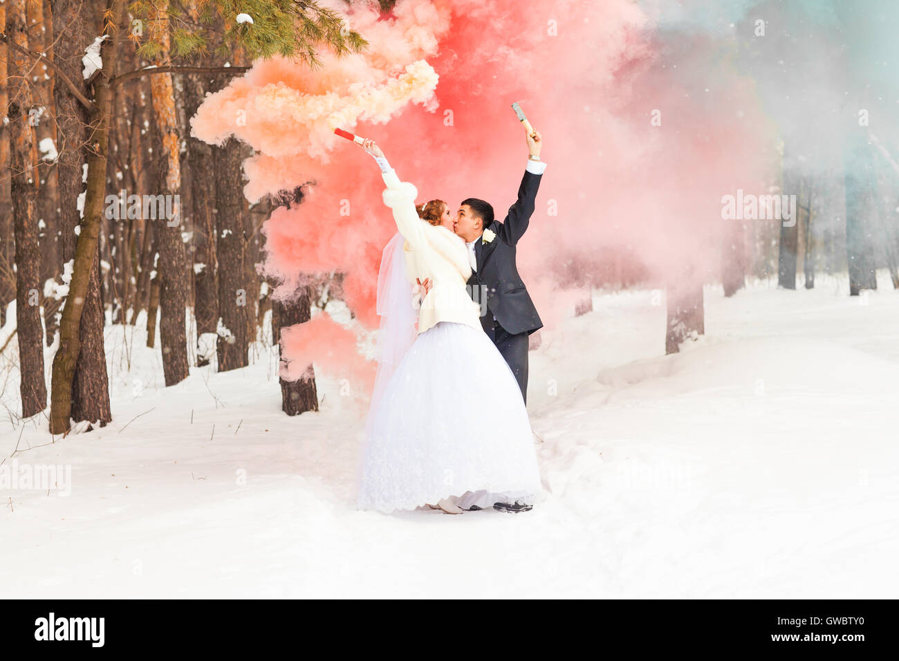 The bride and groom with smoke bombs in winter Stock Photo - Alamy