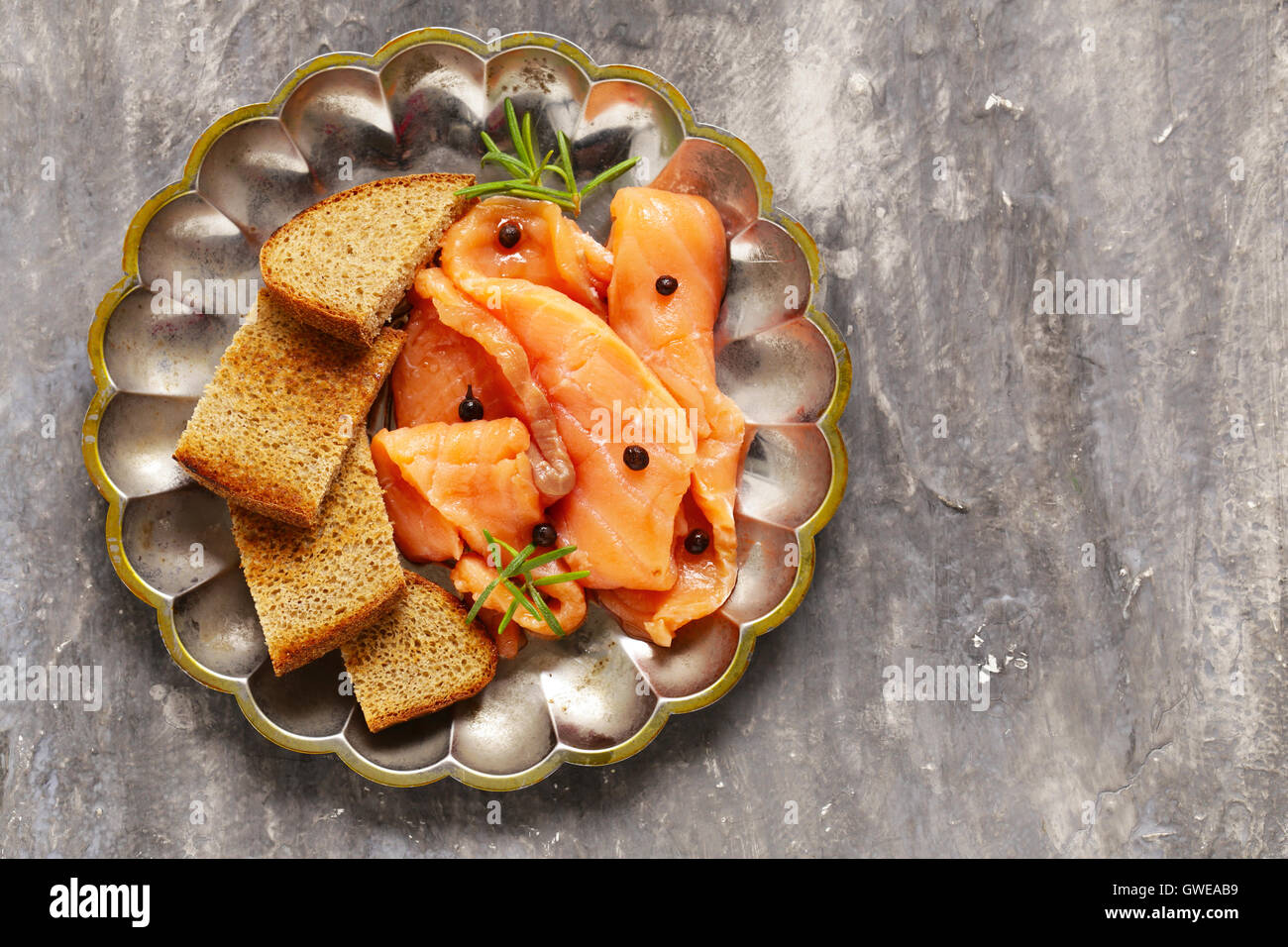 salty salmon red fish with black pepper and rosemary Stock Photo - Alamy