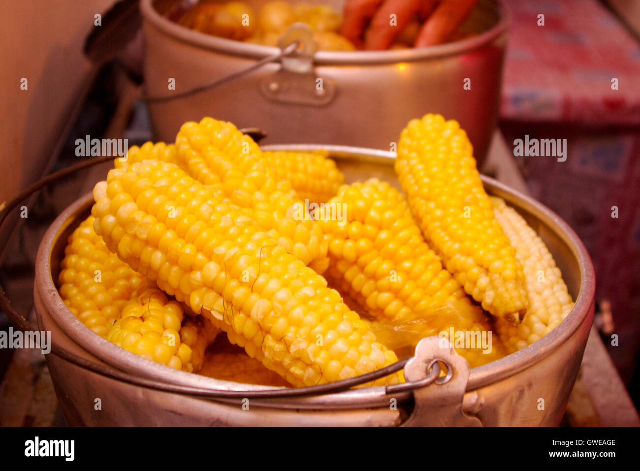 Entire pot of yellow corn ready to served, behind some fried bananas ...