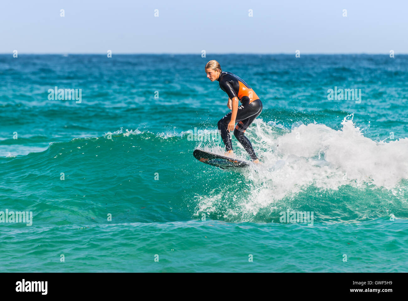 A man rides his surfboard towards the shore Stock Photo - Alamy