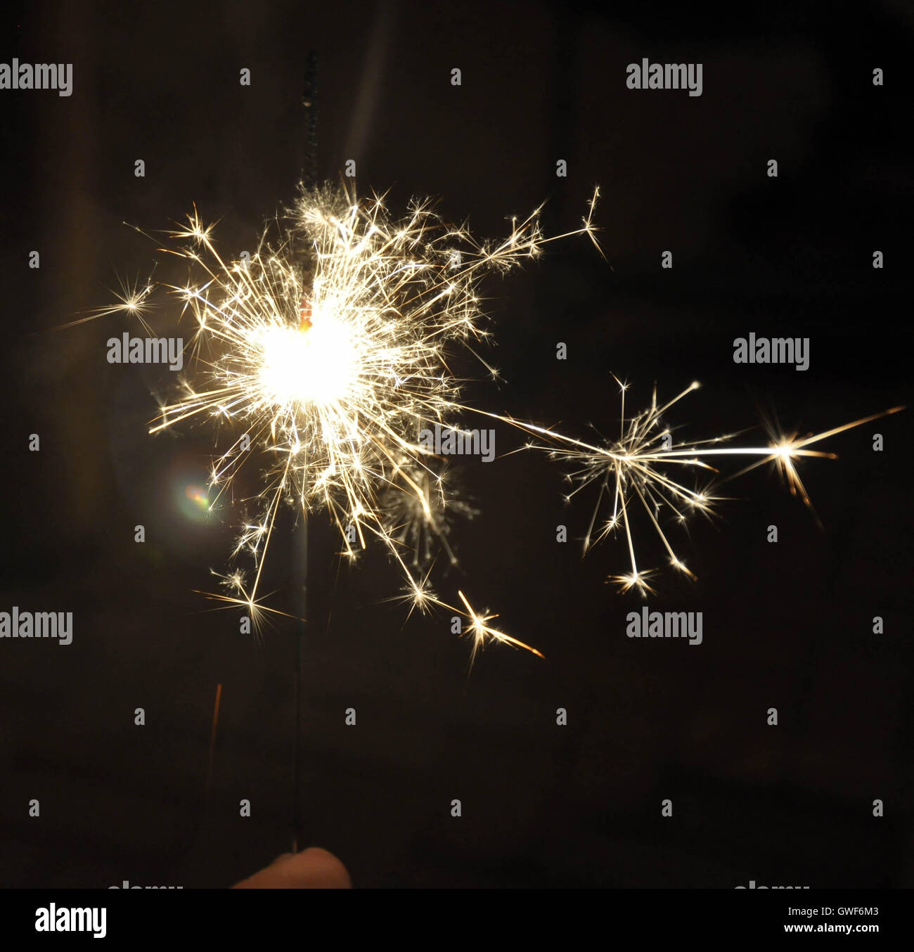 Closeup of handheld sparkler firework illuminated with a dark night ...