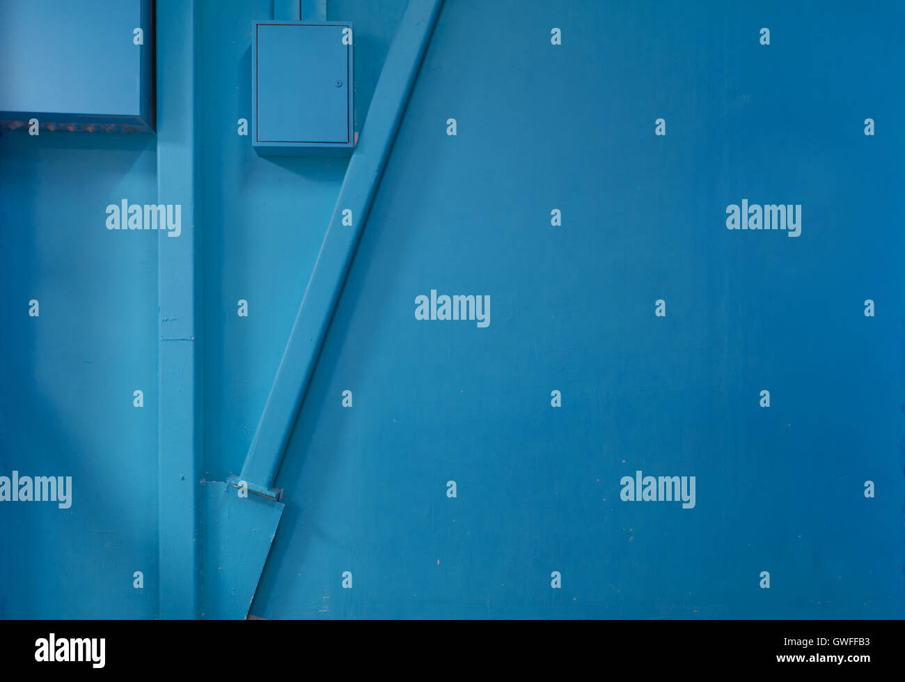 Empty blue wall with some construction elements, industrial background ...