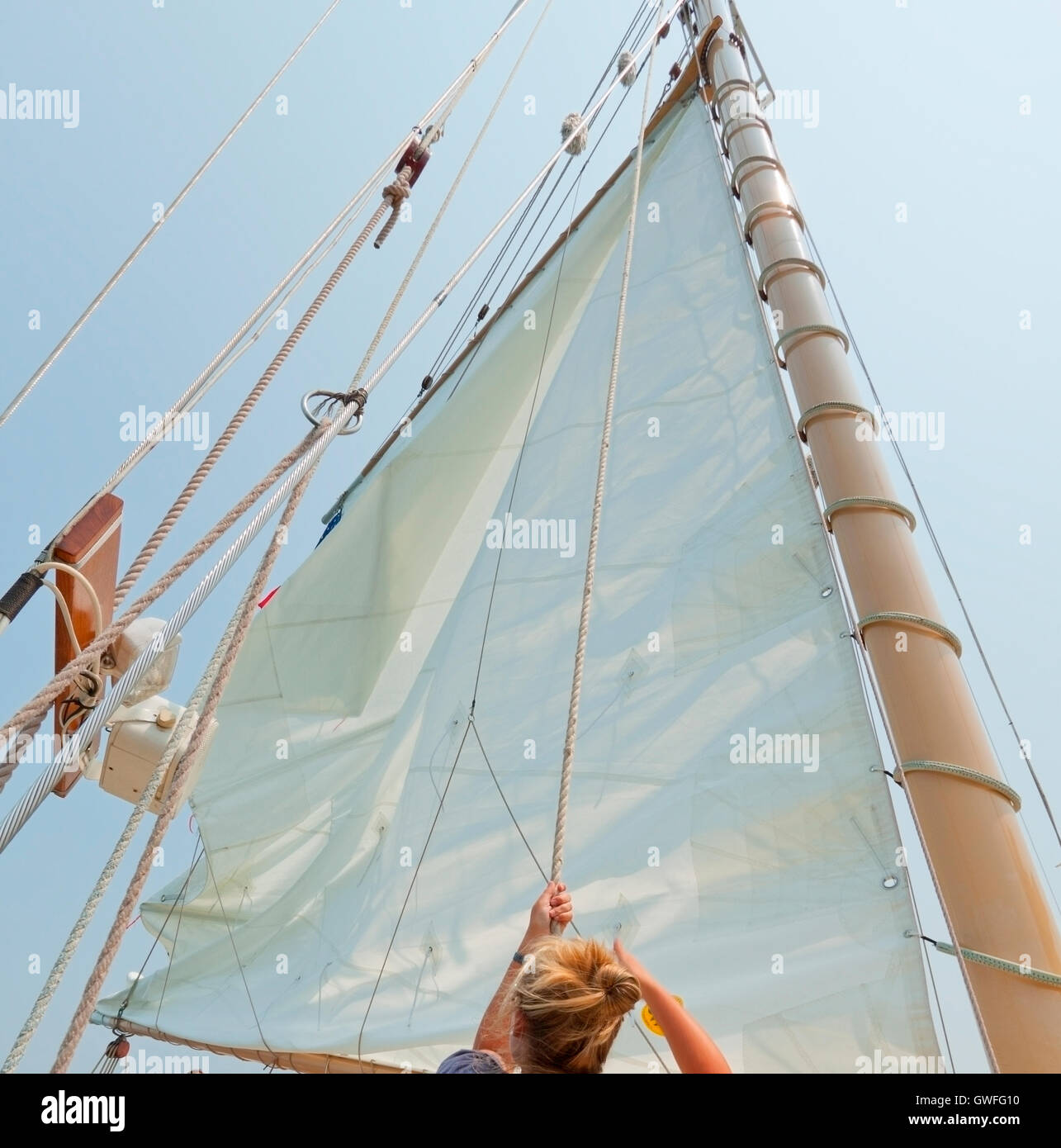 Female crew member raising sail on the private sail yacht Stock Photo ...