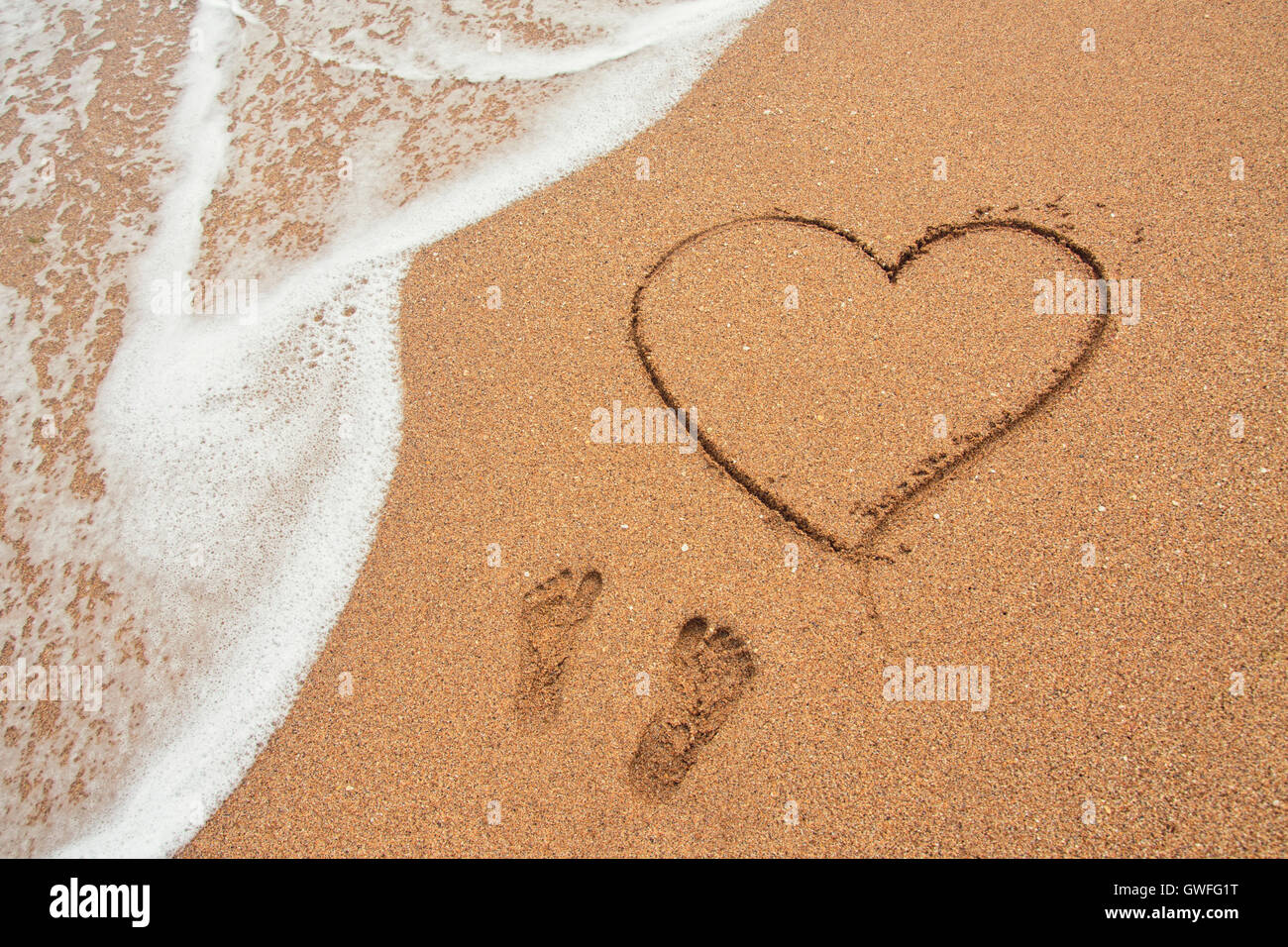 Shape of the heart and footprints in the sand on the beach Stock Photo ...